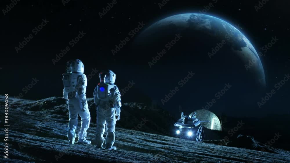 Two Astronauts in Space Suits Stand on the Moon Looking at the ...