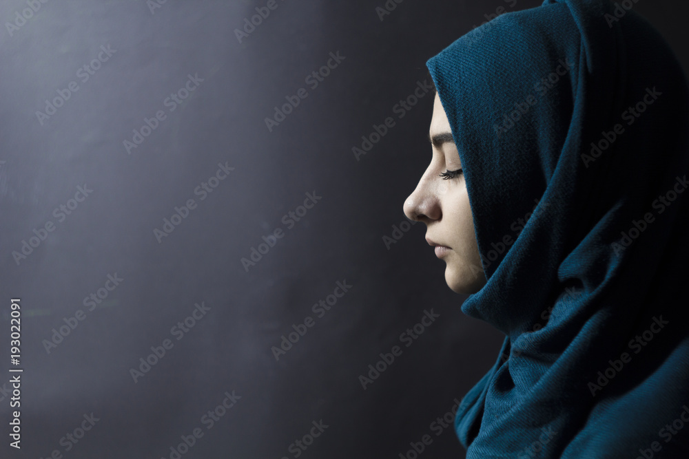 A Muslim woman with closed eyes, on a black background. Arab girl in ...