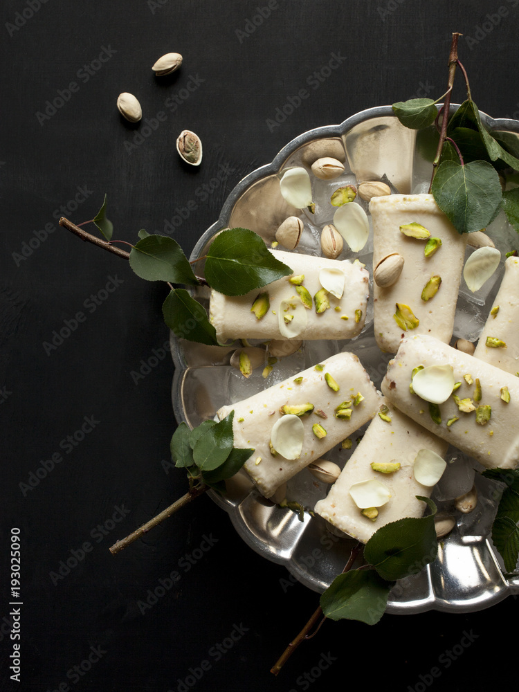 Pista kulfi, Indian ice cream on serving plate with ice cubes ...