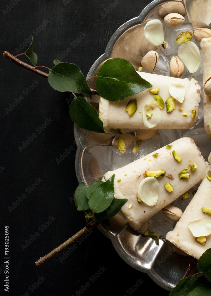 Pista kulfi, Indian ice cream on serving plate with ice cubes ...