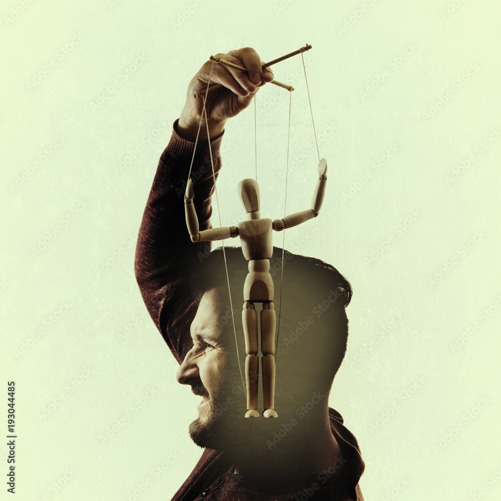 Side view of man holding puppet of his head against white background ...