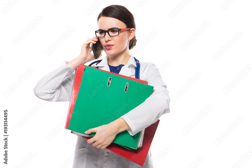Angry young woman doctor with stethoscope holding binders in her hands ...