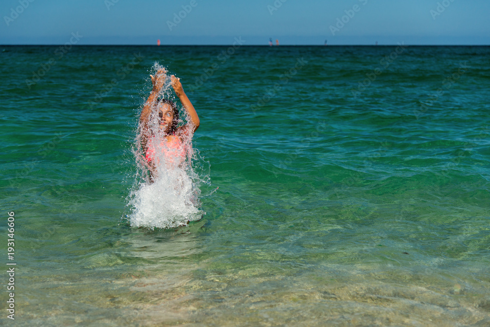 Girl having fun bathing in to the sea and splashing water Stock Photo ...