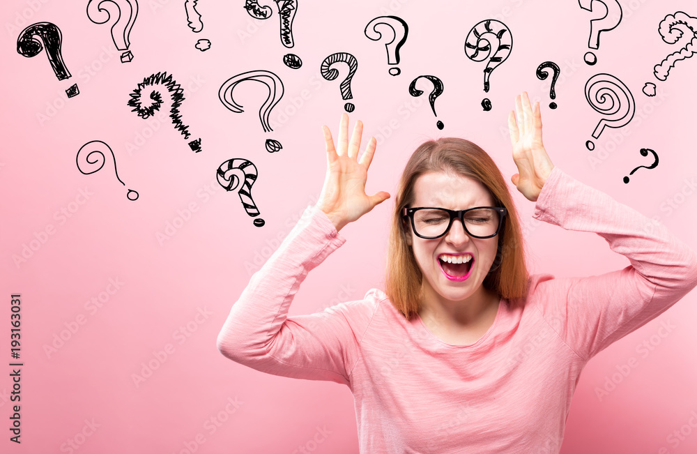 Question Marks with young woman feeling stressed on a pink background ...