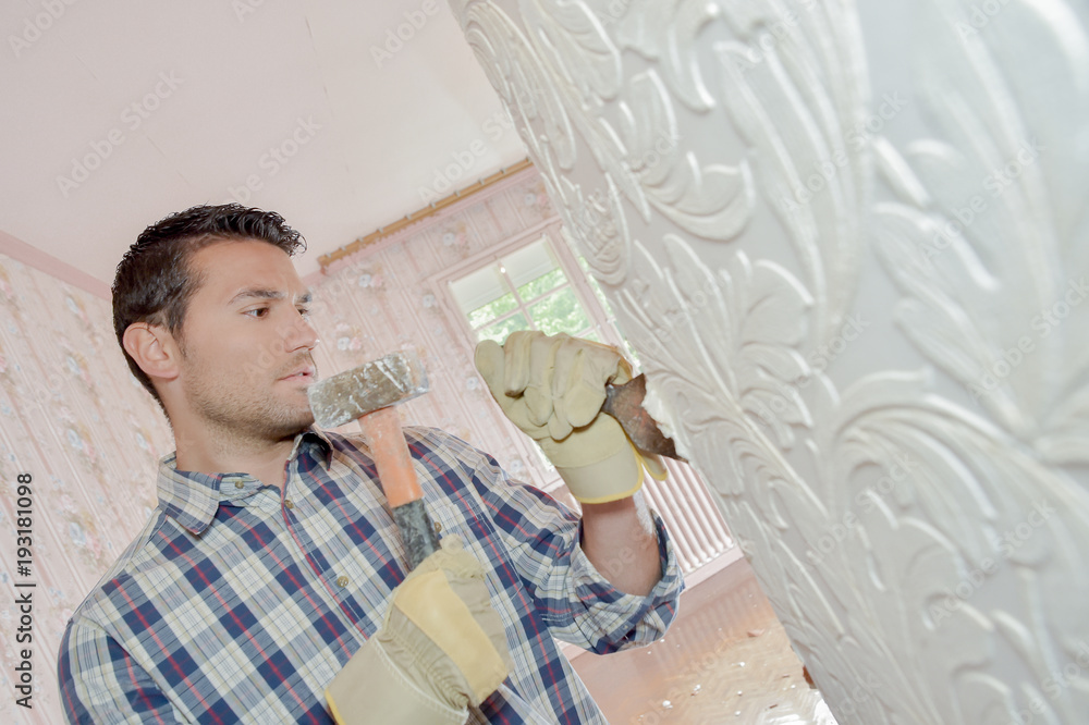 Chiselling away at an old wall motif Stock-Foto | Adobe Stock