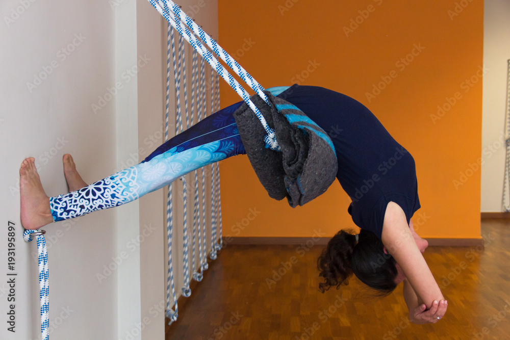 Iyengar female yogi in blue sportswear practicing calisthenics exercise ...
