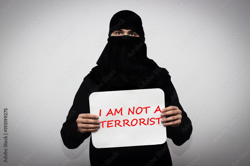 Muslim woman in hijab holding a poster with an inscription (I AM NOT A ...
