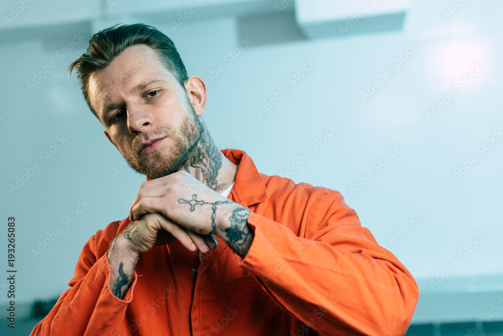 prisoner with tattoos looking at camera in prison cell Stock Photo ...