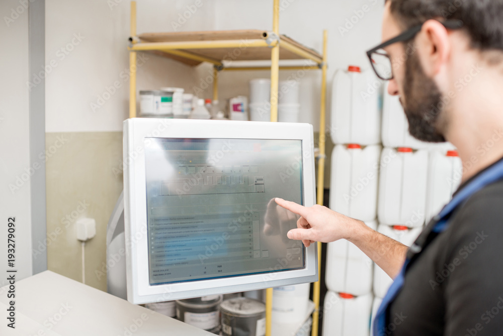Man setting up printing machine touching the screen on the operating ...