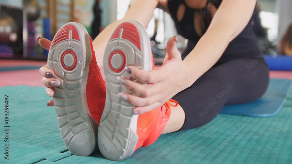 Straching in the gym - young woman exercising healthy lifestyle in ...