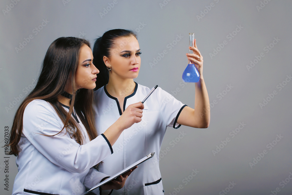 Young scientists holding flask with reagents and making test or ...