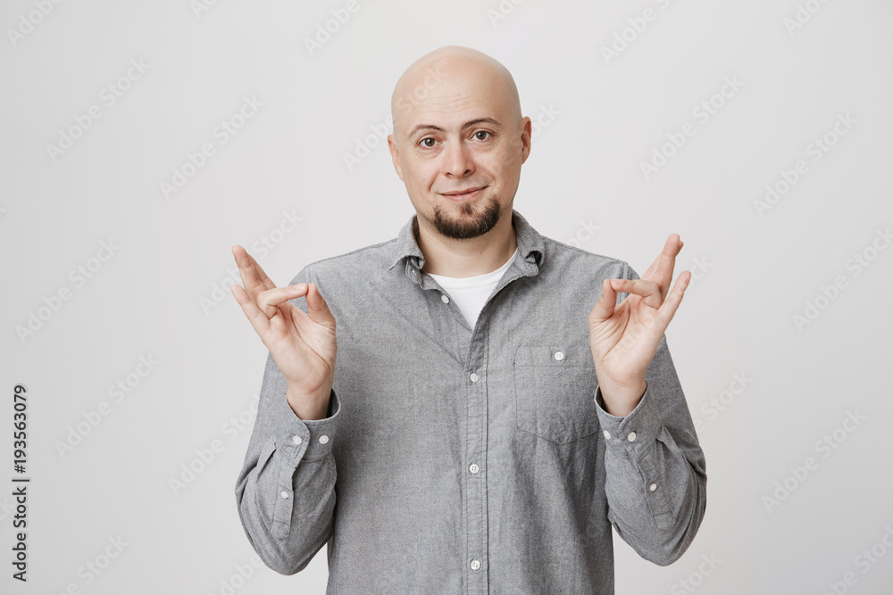 Handsome bearded guy raising his hands in zen gesture over white ...
