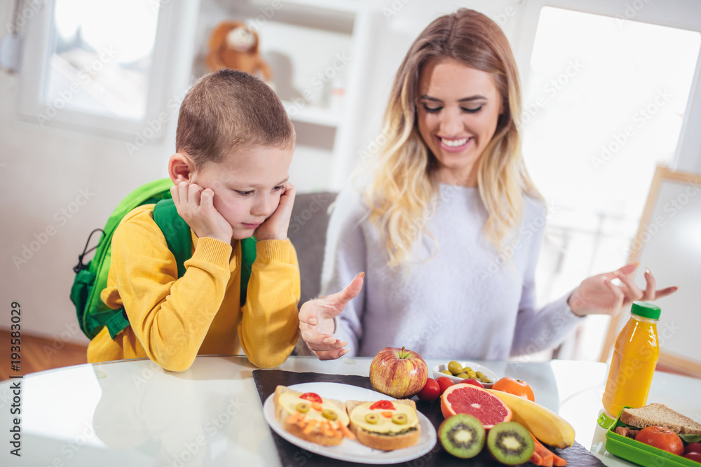 Mother making breakfast for her children in the morning and a snack for ...