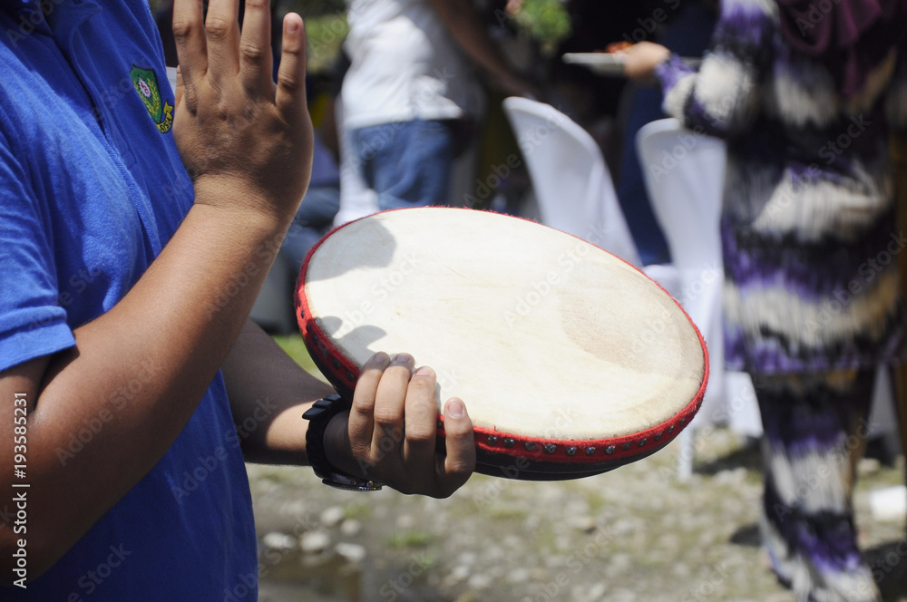 Boy plays Kompang during Malay wedding ceremony. Kompang is a Malay ...