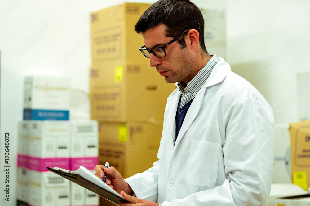 Hombre con bata blanca y cajas de fondo Stock 写真 | Adobe Stock