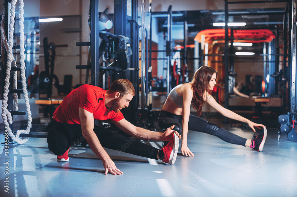 sports girls in the gym teamwork perform exercises for the muscles of ...