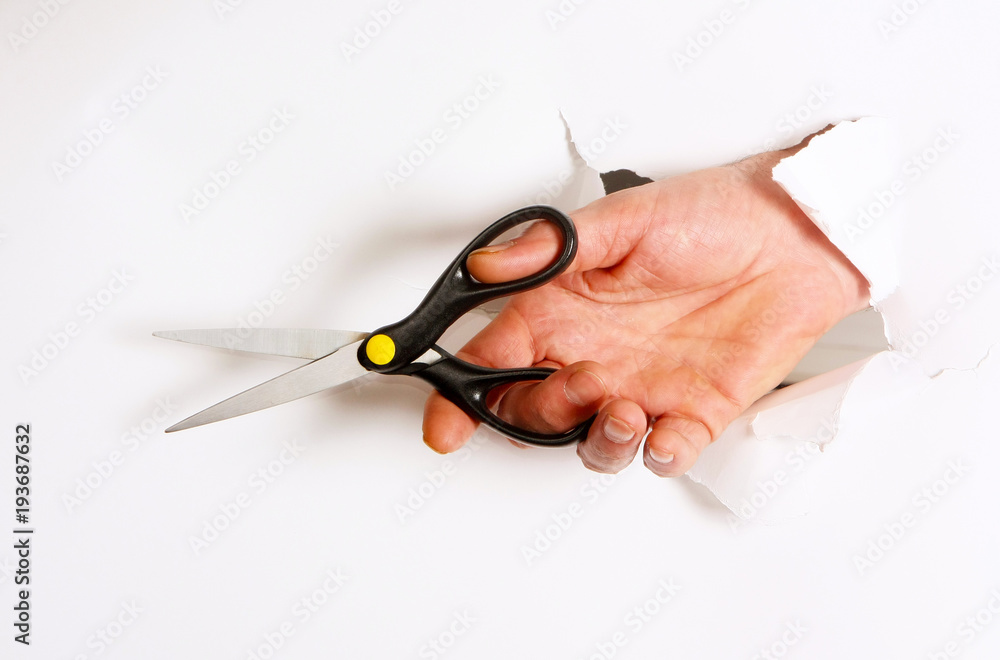 Fingers cut with scissors through a hole on a white background. Concept ...