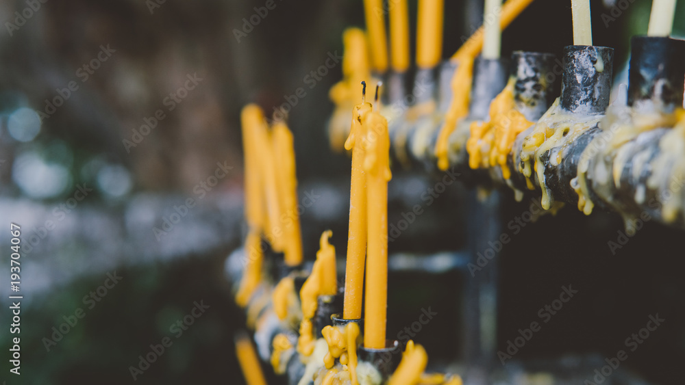 Burning wax candles in a Buddhist temple close-up. Rituals of worship ...