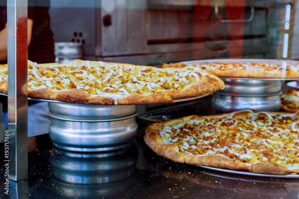 Pizza resting on a pizzeria counter the background is restaurant Stock ...