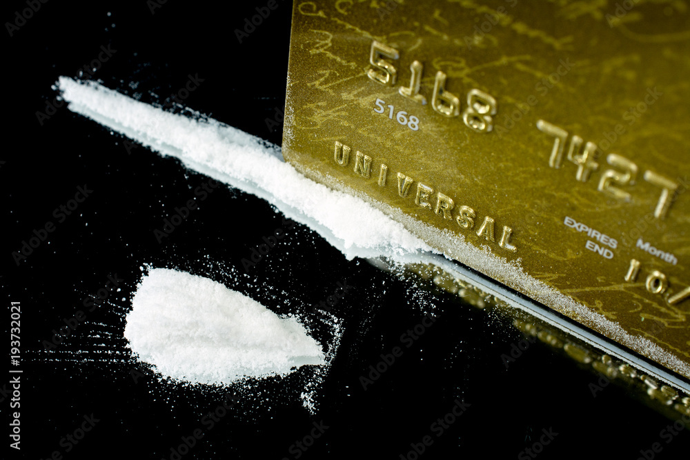 snorting and sniffing cocaine lines on mirror with rolled banknote gold ...