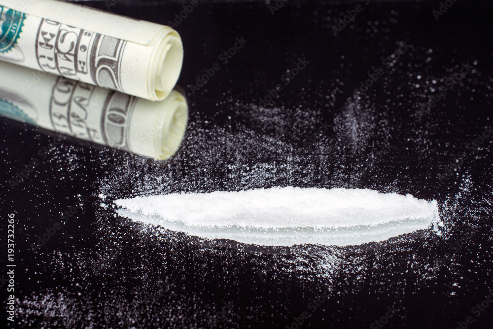 snorting and sniffing cocaine lines on mirror with rolled banknote ...