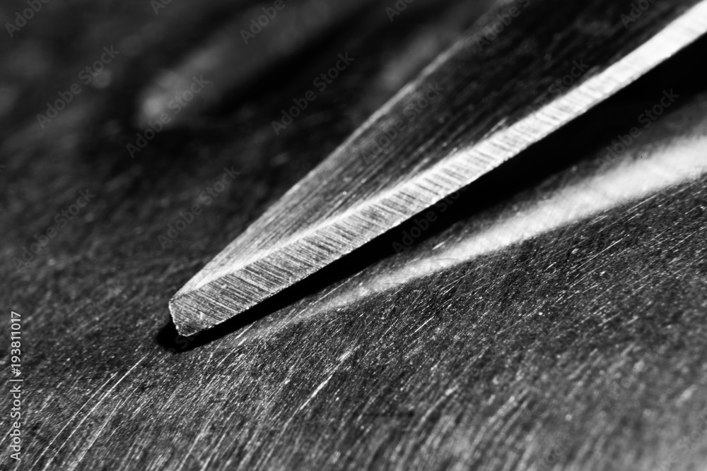 Grunge black and white background with a knife on a metal surface macro ...