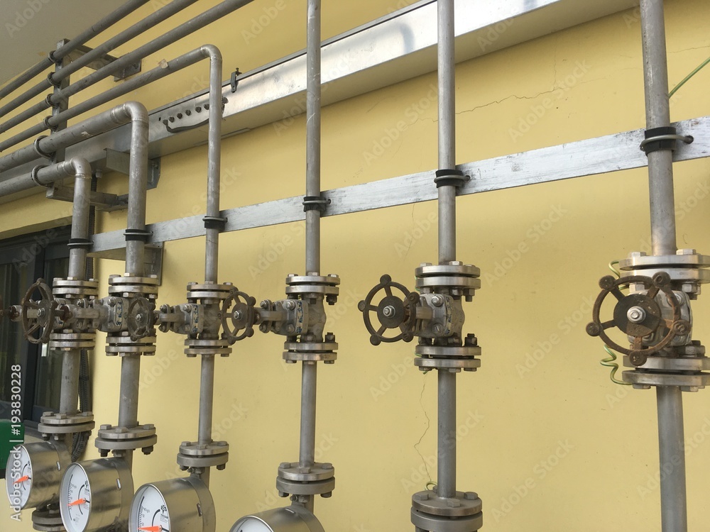 Poster Valve with hand wheel, tubes, and flanges fitting in a factory ...