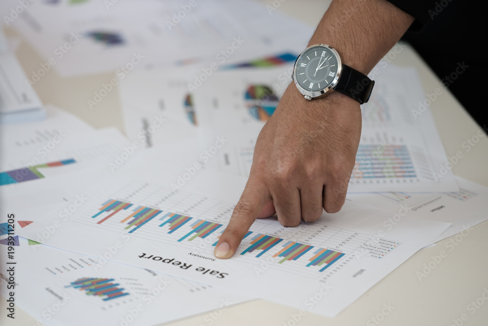 Hand of business man pointing to a paper chart sales report. investment ...