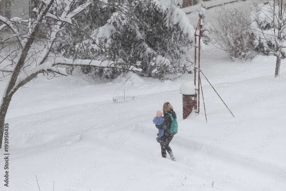 Winter. People walk on a very snowy sidewalk and road. People step on ...
