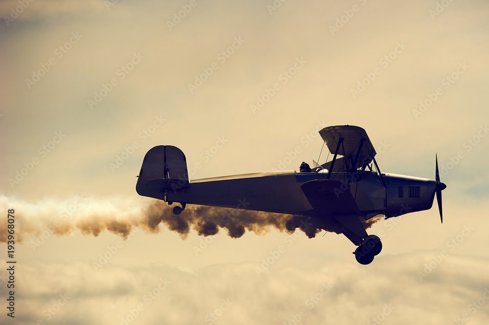 Vintage single engine propeller biplane aircraft flying against sky ...