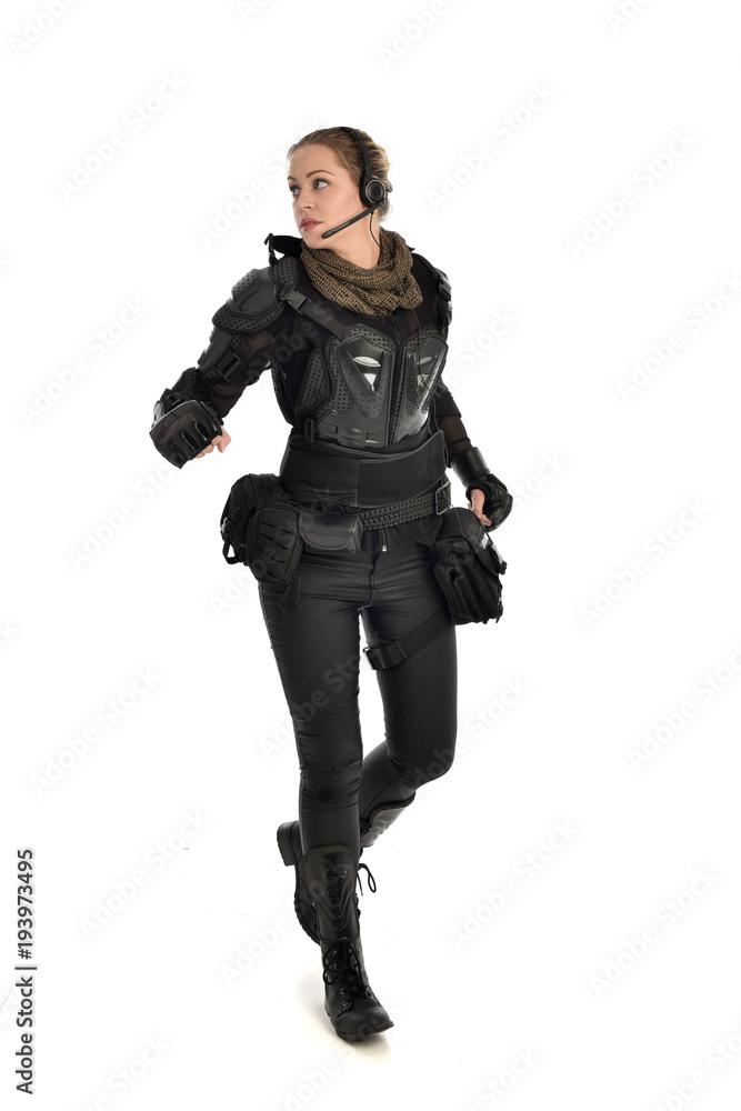full length portrait of female soldier wearing black tactical armour ...