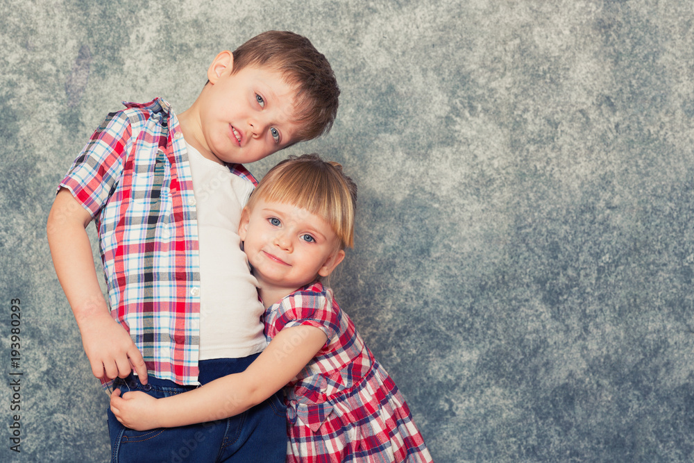 Two children: a boy and a girl dressed in red checkered clothes ...