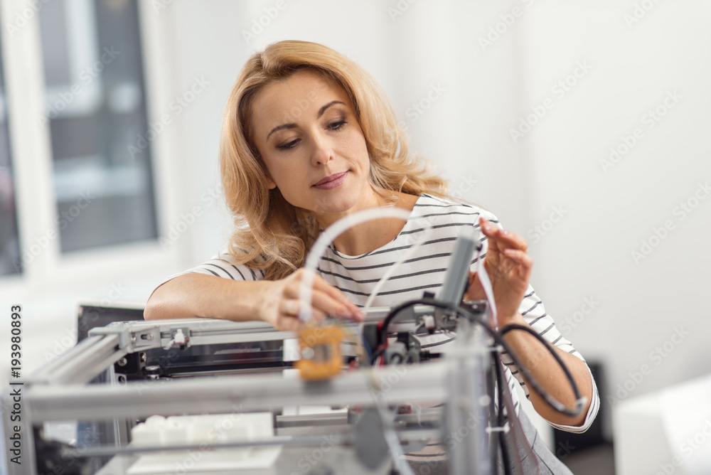 New beginning. Charming young woman using the touchscreen of a 3D ...