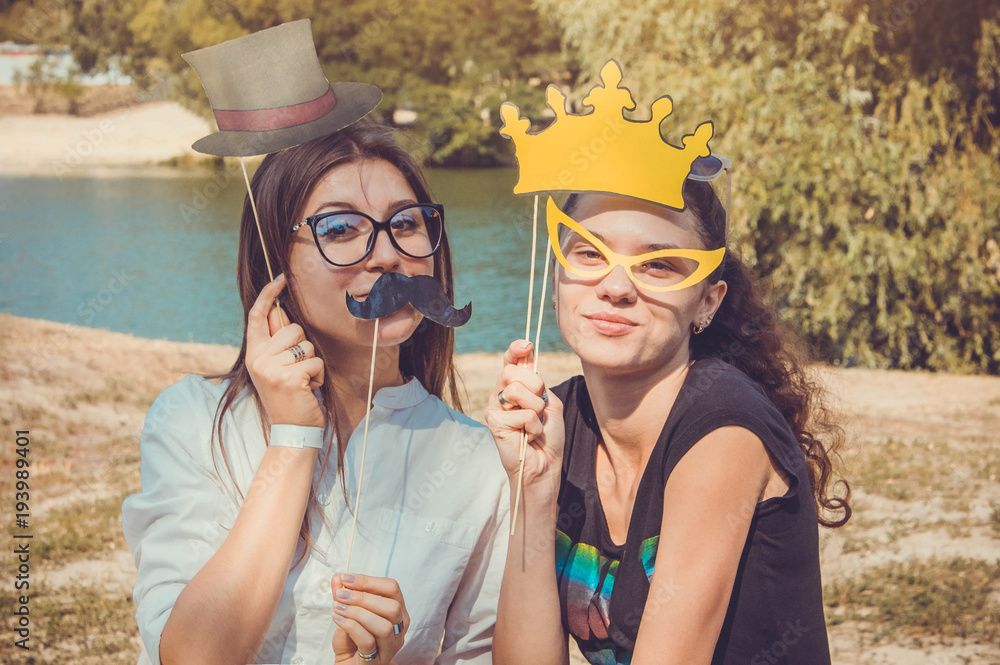 Two young women posing using photo booth props Stock Photo | Adobe Stock