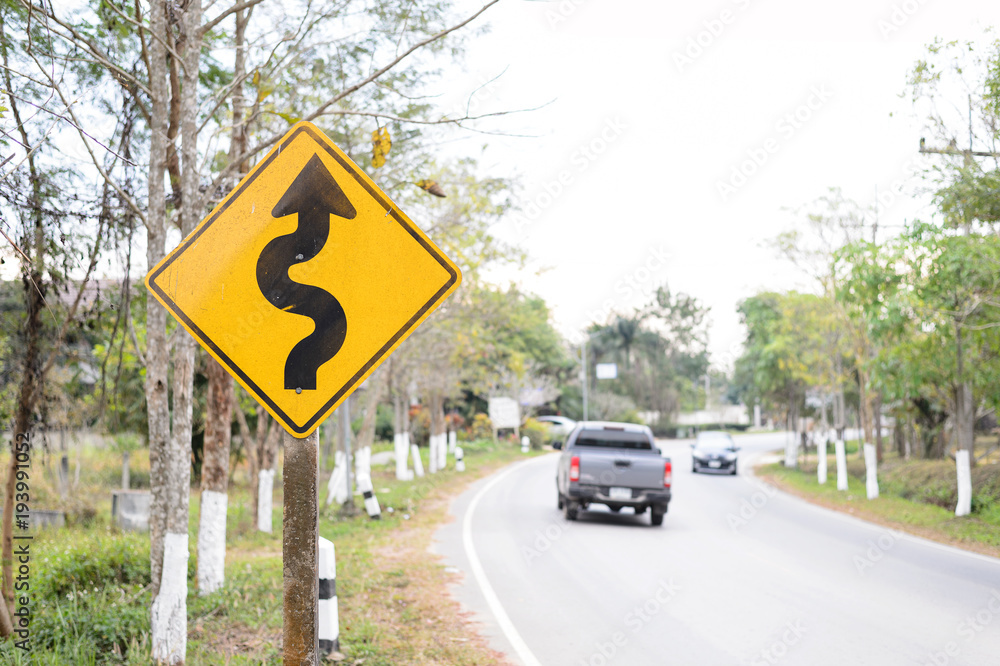 curvy road sign with soft-focus and over light in the background Stock ...
