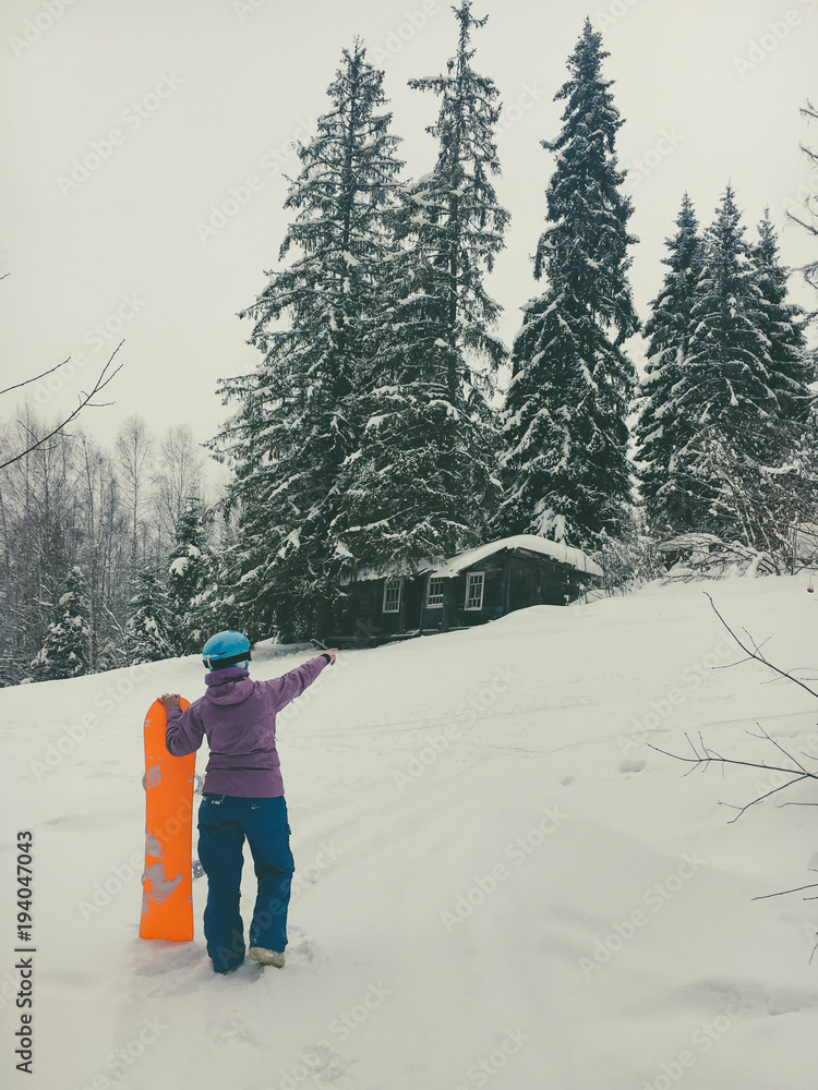snowboard girl in a blue helmet stands with her back holding board next ...