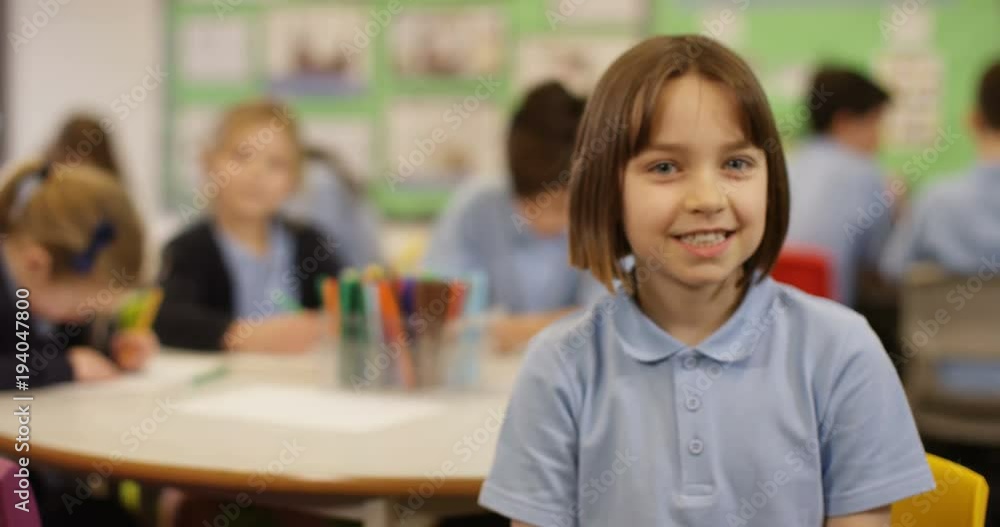 4K Portrait cute smiling little girl in primary school classroom. Slow ...