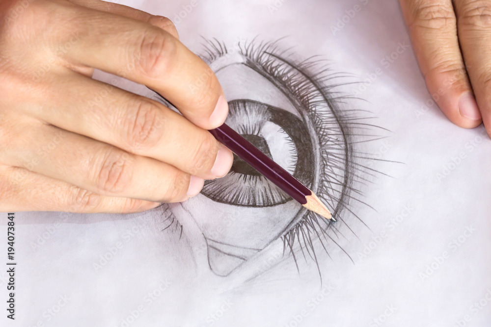 Drawing eye with pencil. Close up hands with pencil drawing human eye ...