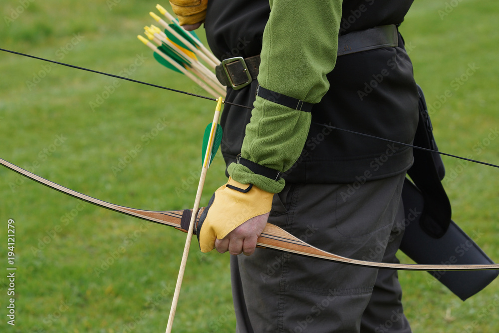 An archer standing ready with an arrow on nocked on to an American ...