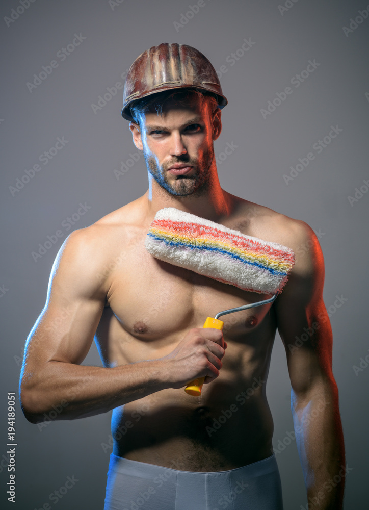 Handsome worker with paint roller. Painter man. Muscular painter man ...