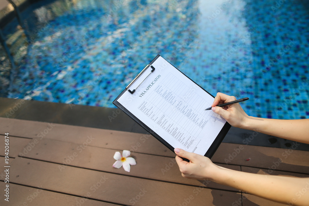 woman holds pen and visa application in UAE Dubai, contributes her data ...