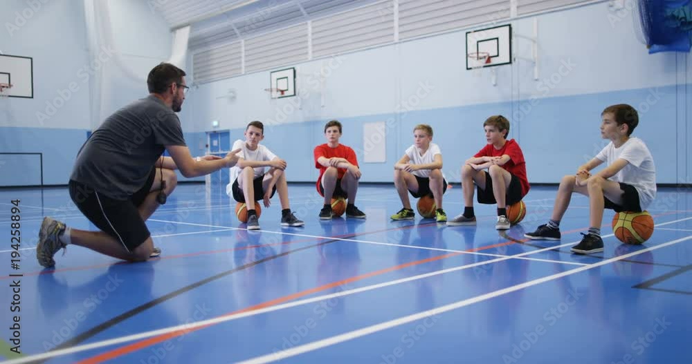 4k, A male coach talking to a group of teenage boys during a physical ...