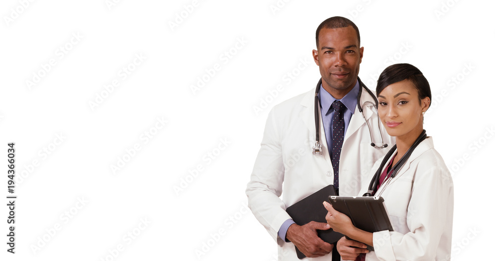 Two African American doctors posing for a portrait while holding their ...