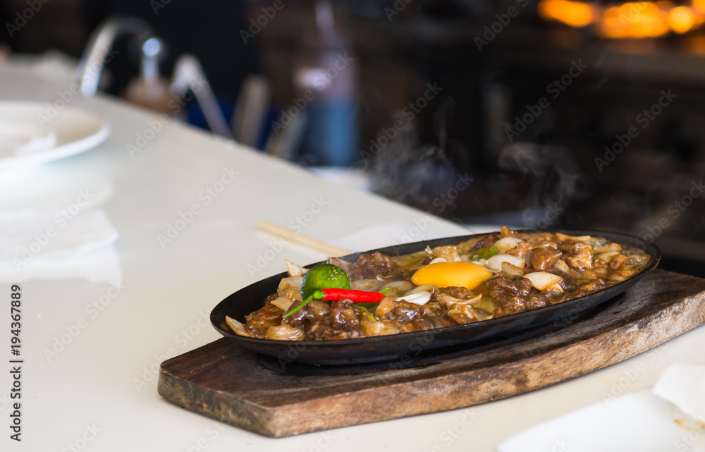 sizzling pork sisig with raw egg Stock Photo | Adobe Stock