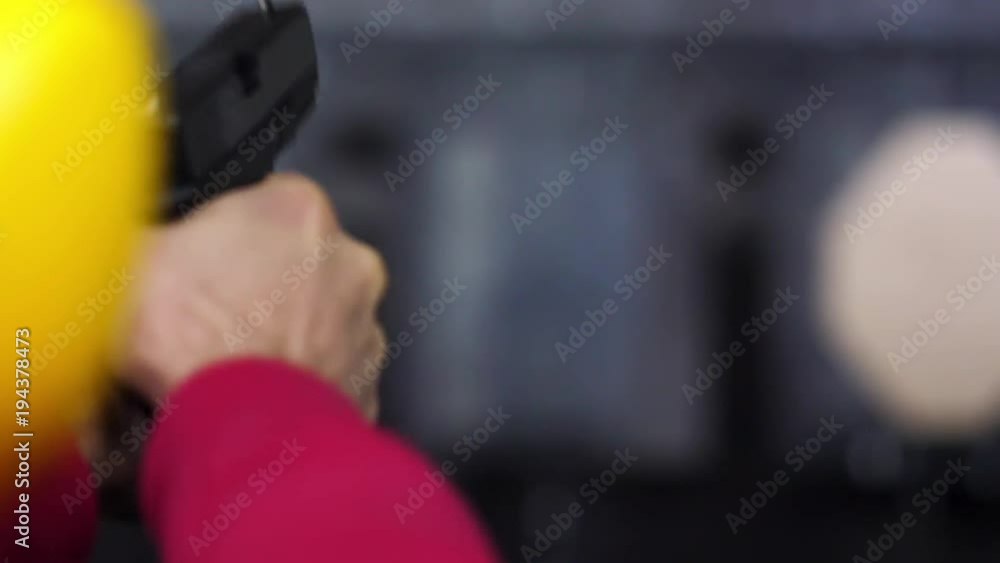 Back view of man shoots a gun at shooting range close up. Man fires ...