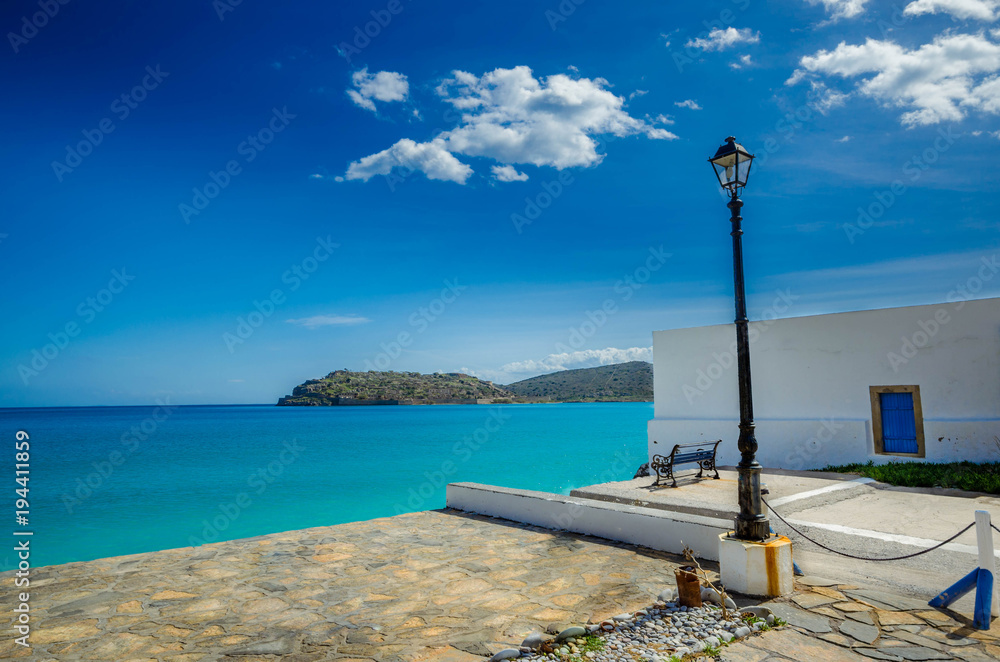 White house with blue window, street light and a bench staring at the ...
