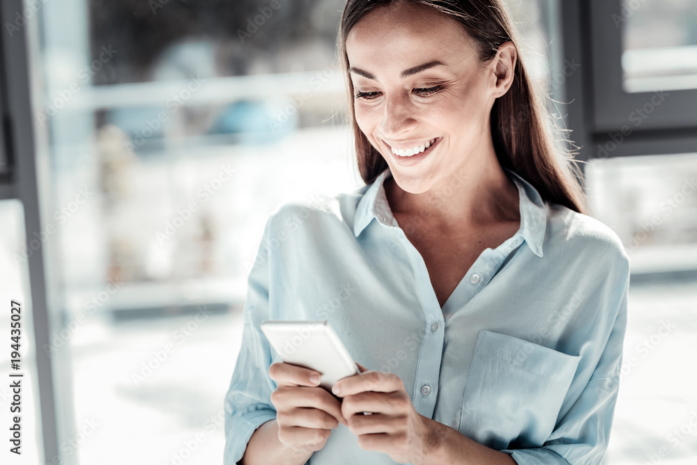 Innovative smartphone. Happy positive smart woman smiling and using her ...