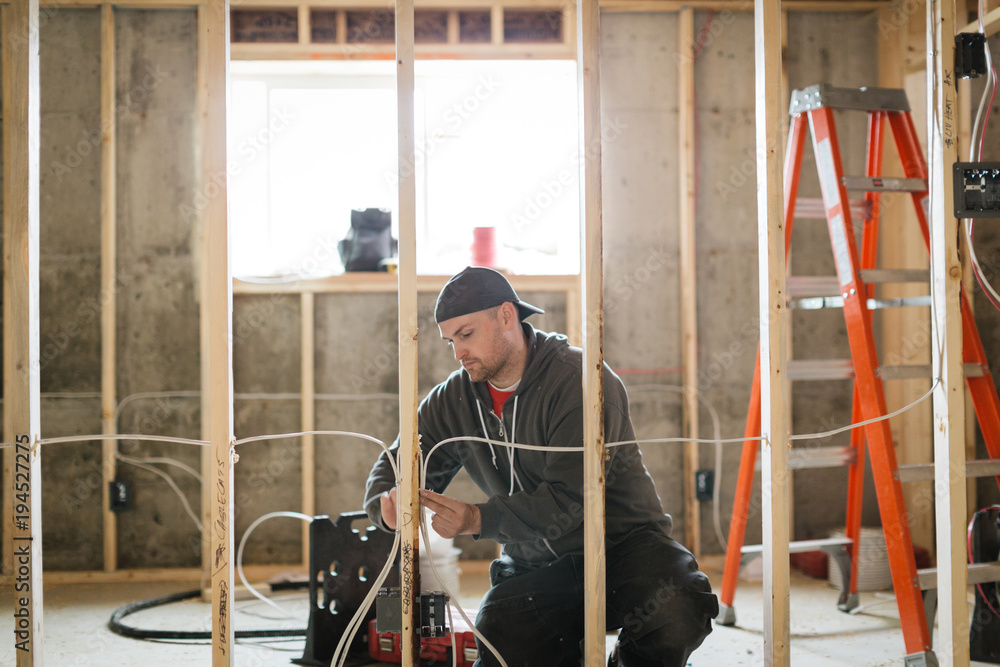 Electrician man installing wire on jobsite Stock Photo | Adobe Stock