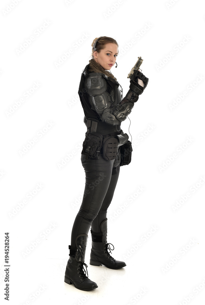 full length portrait of female soldier wearing black tactical armour ...