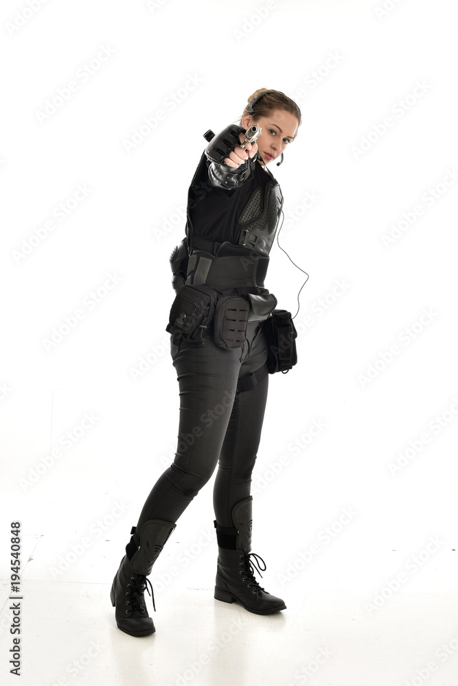 full length portrait of female soldier wearing black tactical armour ...